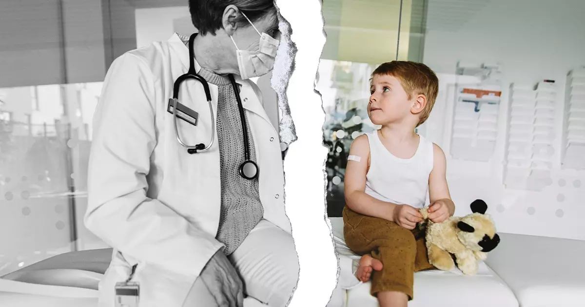 Dítě s plyšákem se dívá na svého pediatra.